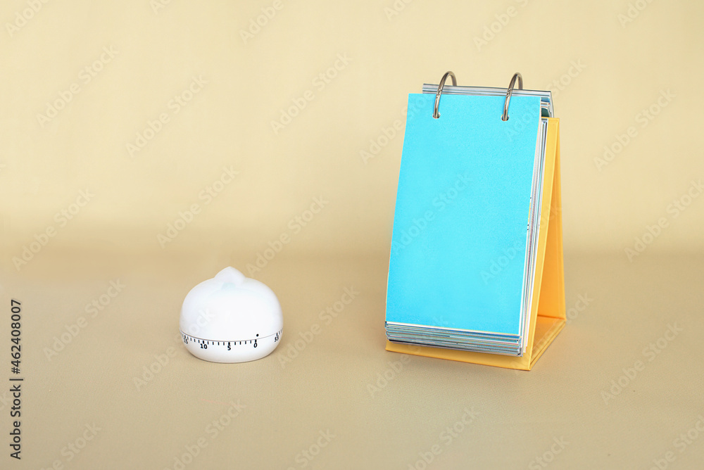 White timer and table flip calendar with a blank bright blue sheet on ...