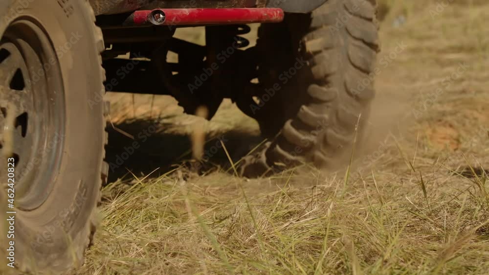 Utility vehicle with flat tire goes forward, raising clouds of dust ...