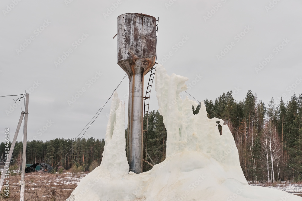water tower with frozen ice, in winter. Accident at the water tower ...