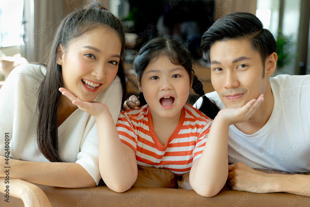 Happy Asian family with their daughter poses together for a portrait on ...