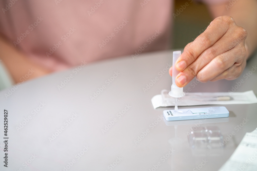 Asian woman using rapid antigen test kit for self test COVID-19 ...