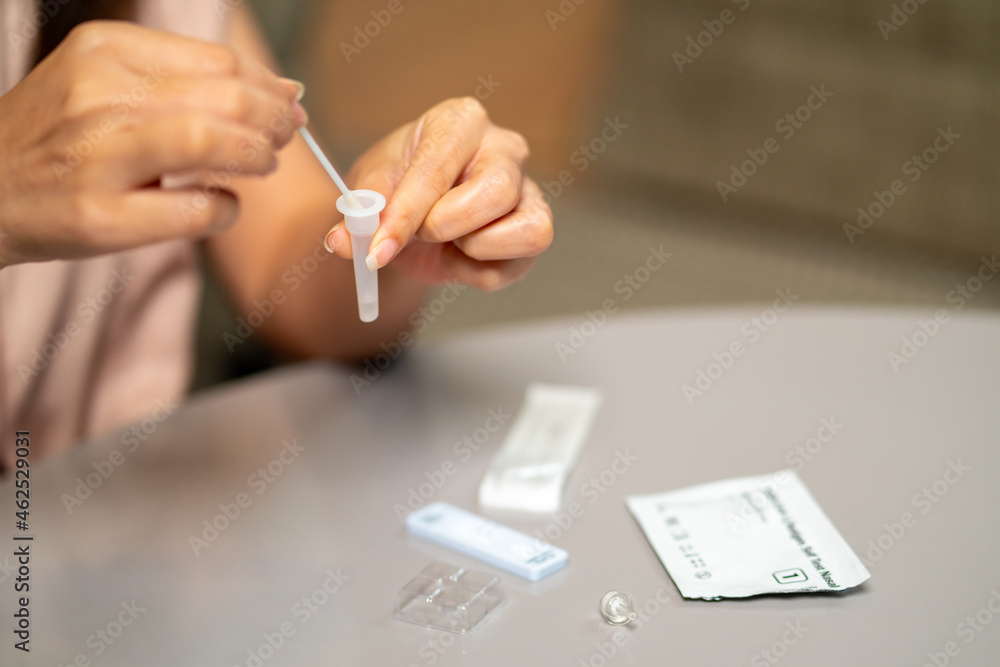 Asian woman using rapid antigen test kit for self test COVID-19 ...