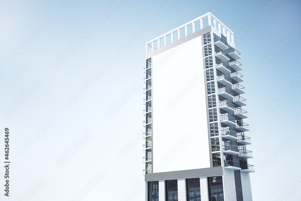 Skyscraper with empty rectangular white billboard banner on blue sky ...