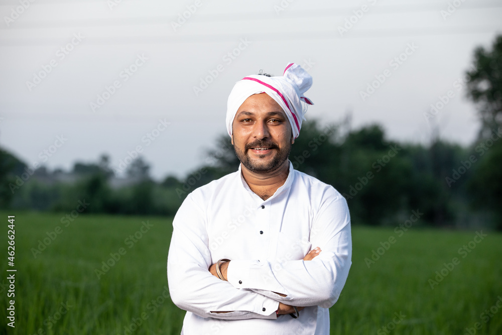 Happy rural Indian mustache man farmer standing in field with hands ...