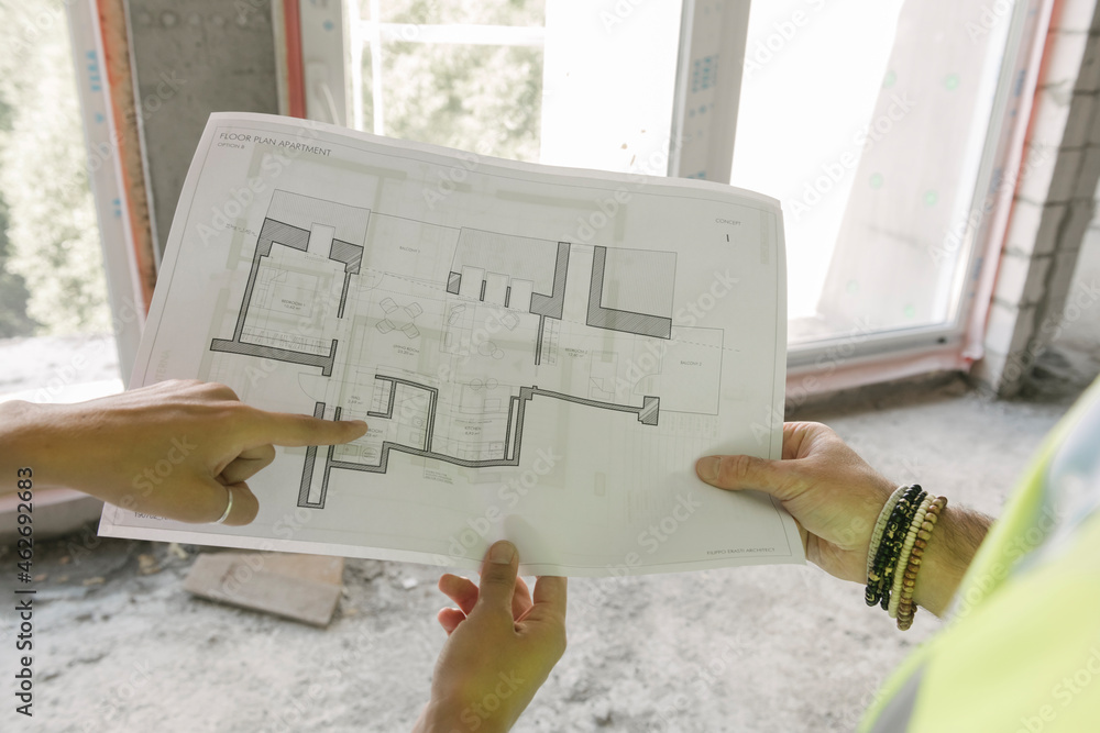 Two architects pointing a architectural plan at construction site Stock ...