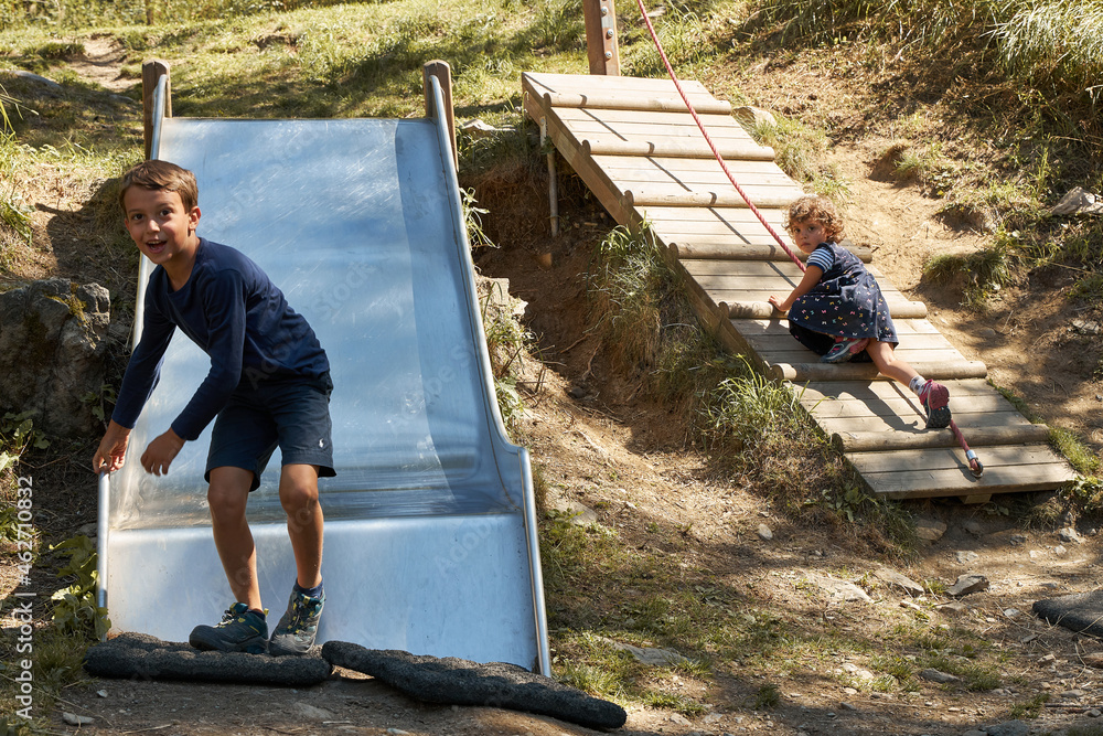 Brother and sister play together in the fresh air. The boy descends ...