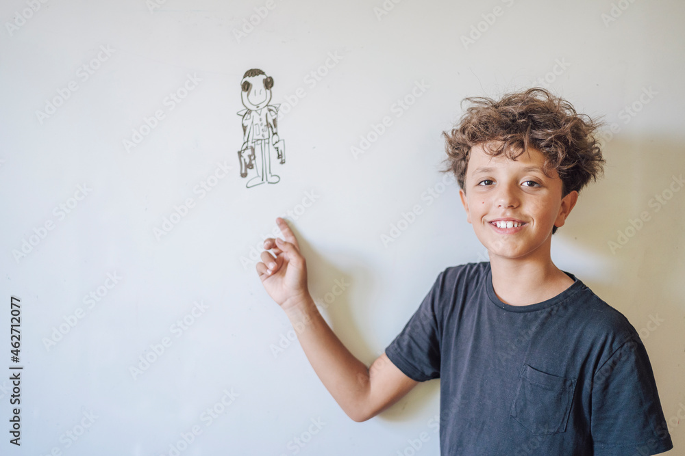 Portrait of smiling boy pointing to a drawing on a whiteboard Stock ...