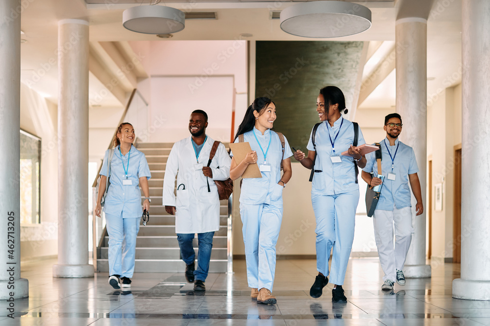 Multi-ethnic group of happy medical and nursing students walk through ...