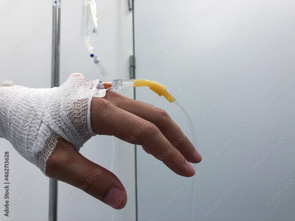 Intravenous therapy in a white hospital room with copy space. Hand with ...