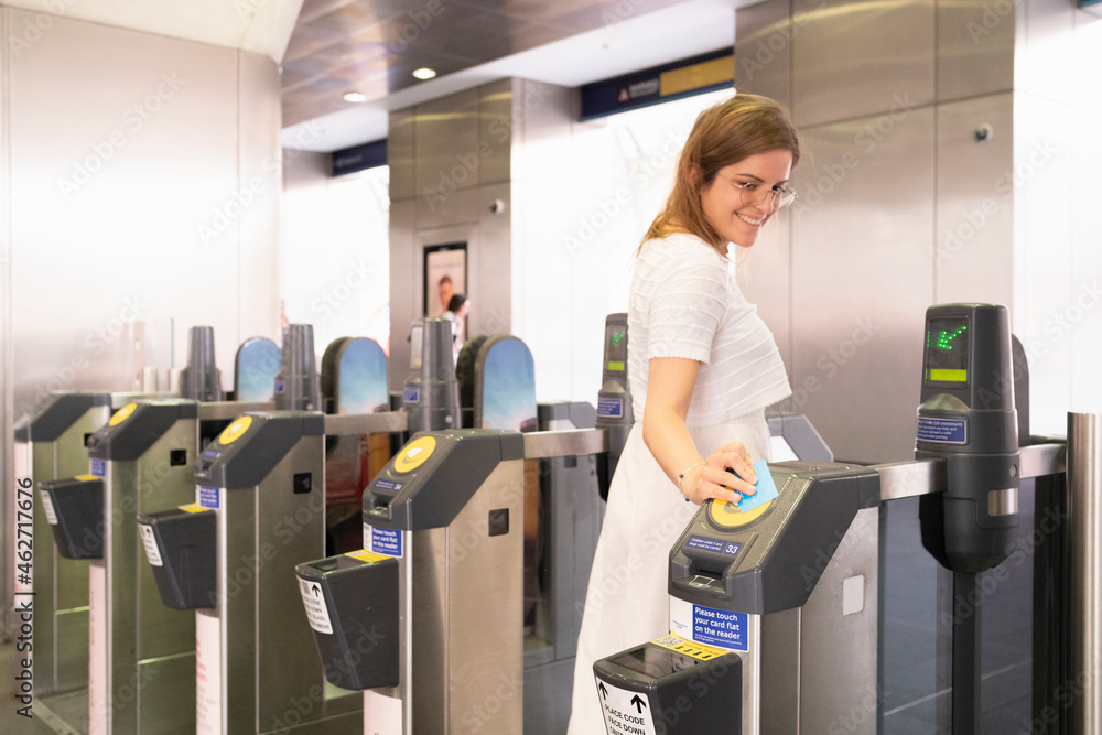 Smiling woman passing subway gate with electronic ticket Stock Photo ...