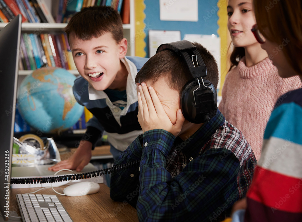 Children playing on a computer in classroom Stock Photo | Adobe Stock