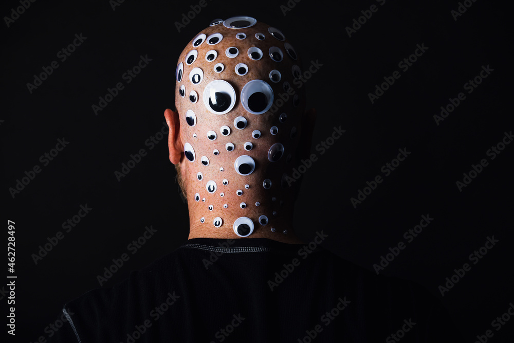 Foto de Bald man with head covered in googly eyes do Stock | Adobe Stock