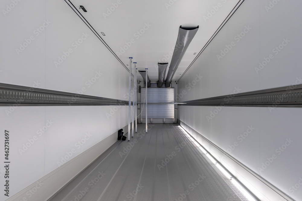 Empty refrigerated semi-trailer inside, with cargo area lighting. The ...