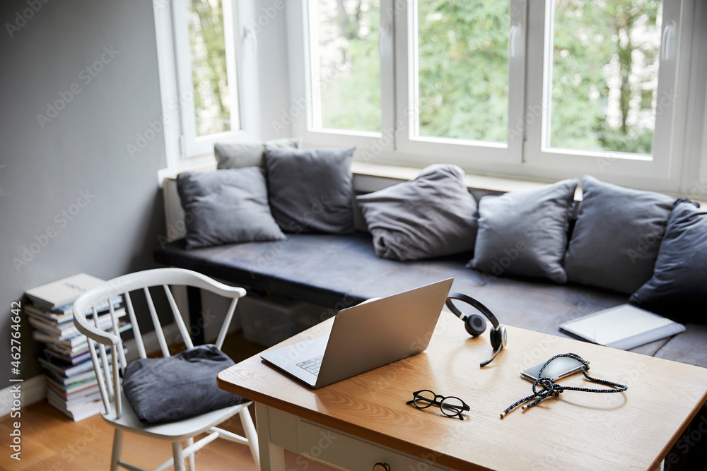 Laptop on table by furniture in living room at home Stock Photo | Adobe ...