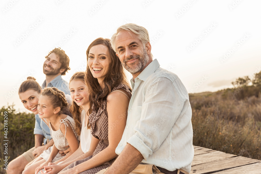 Large family enjoying the sunset sitting on a boardwalk Stock Photo ...