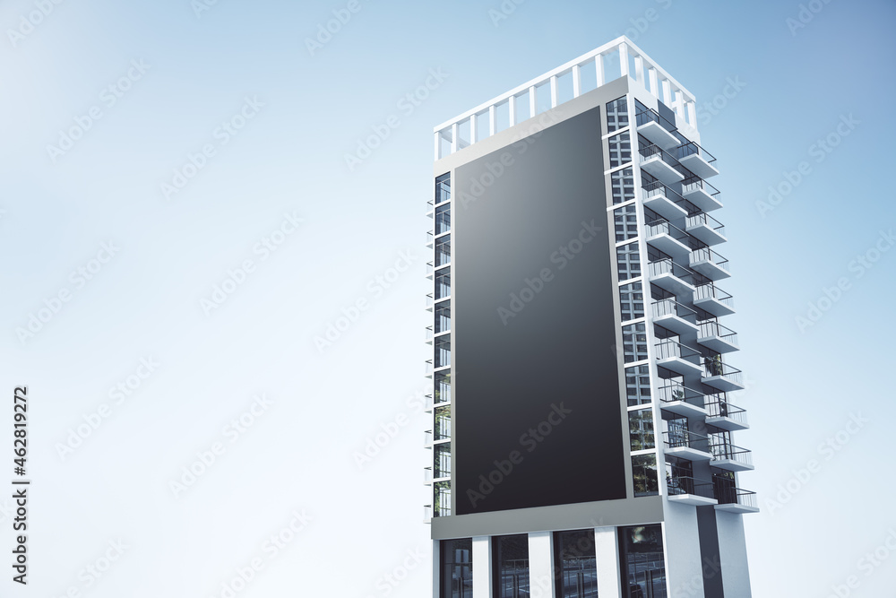 Skyscraper with empty rectangular black billboard banner on blue sky ...