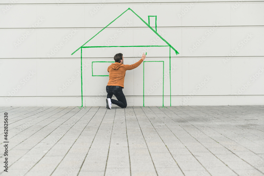 Digital composite of young man drawing a house at a wall Stock Photo ...