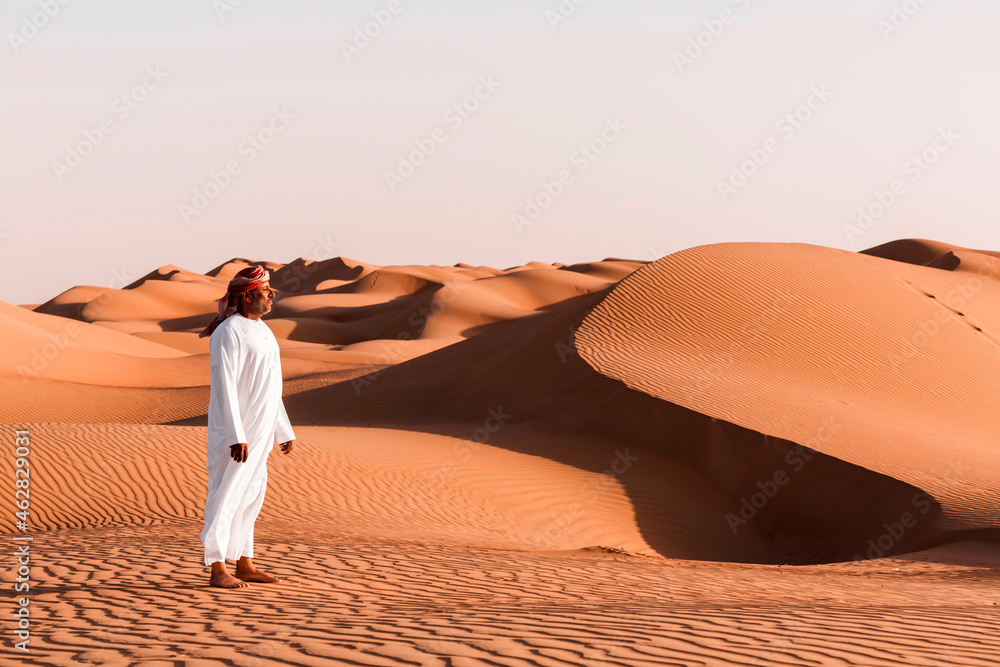 Bedouin in National dress standing in the desert, Wahiba Sands, Oman ...
