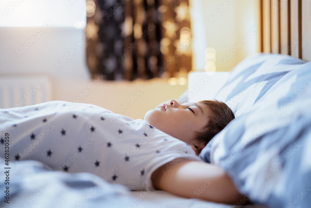 Cute boy sleeping in bed with morning light,Lovely Child get deep sleep while taking a nap,Kid ...