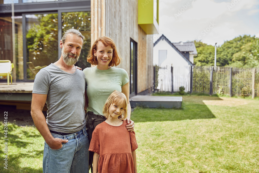 Smiling family standing outside tiny house in yard Stock Photo | Adobe ...
