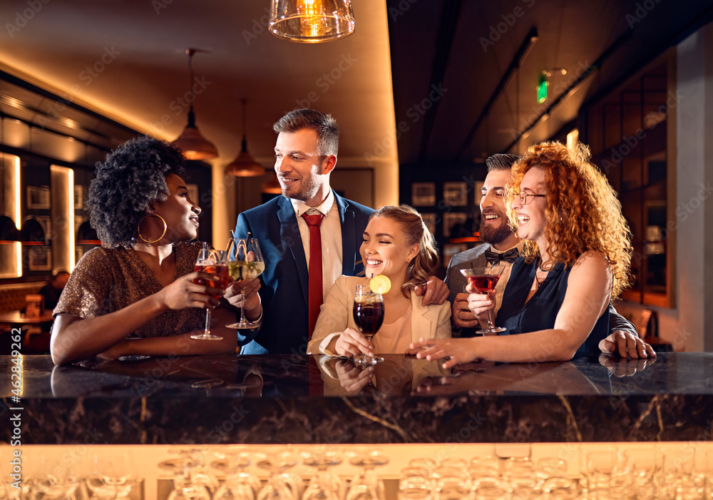 Happy friends socializing in a bar with cocktails Stock Photo | Adobe Stock