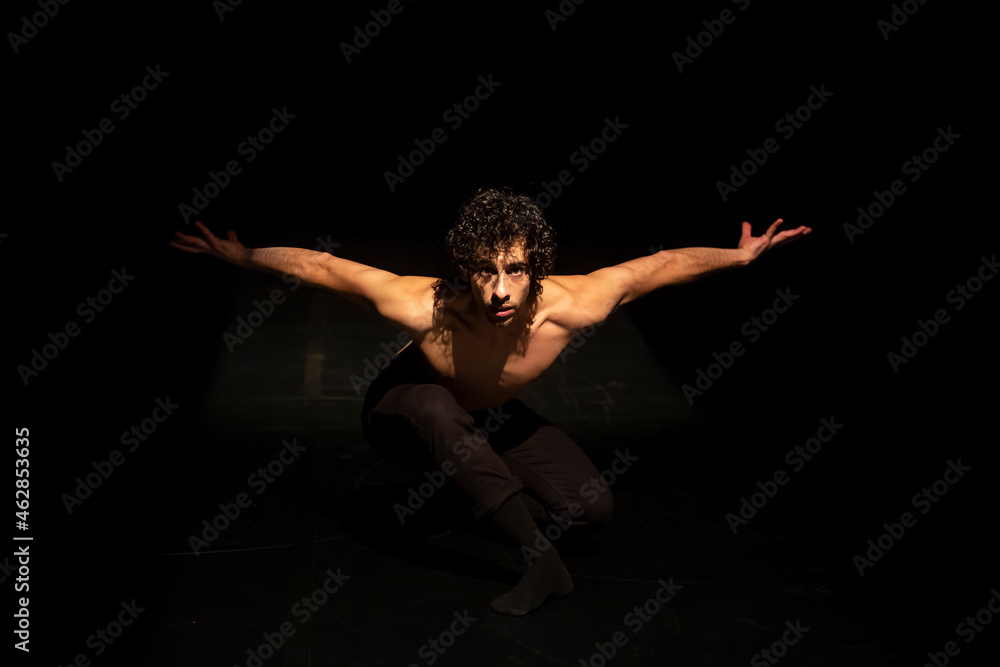 Male ballet dancer performing on black stage Stock Photo | Adobe Stock