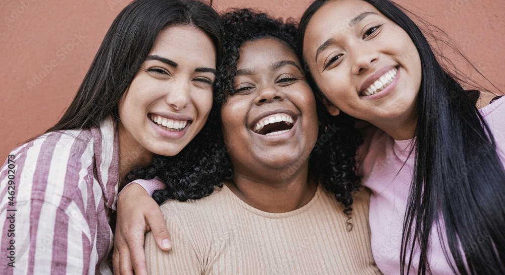 Multiracial young women with different skin color smiling on camera ...