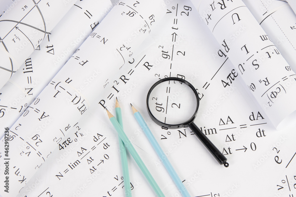rolls of paper drawings with math electrical formulas, magnifier and ...