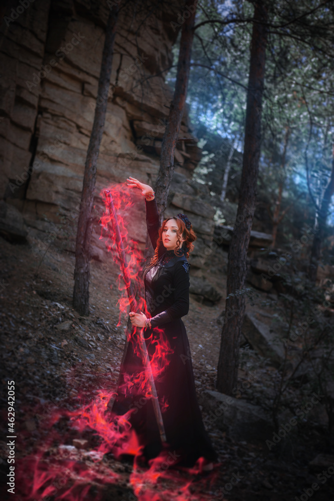 Evil witch with a staff in the forest. Slavic witch creates red magic ...