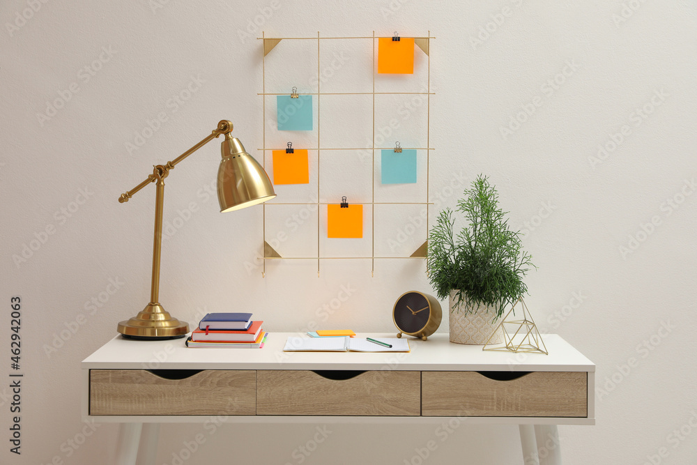Memo board with colorful notes hanging on white wall over desk indoors ...