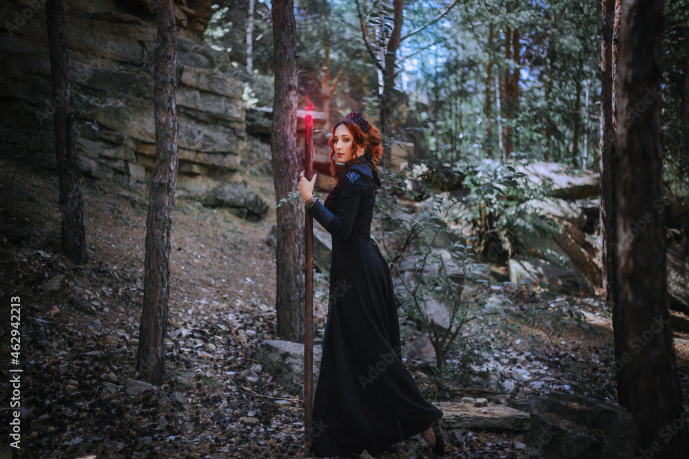 Foto de Evil witch with a staff in the forest. Slavic witch creates red ...