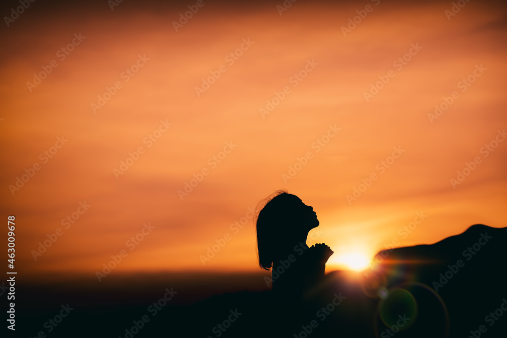young girl standing praying with light of sunset background, christian ...