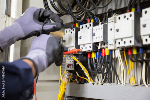 Electrician engineer tests electrical installations and wires on relay ...