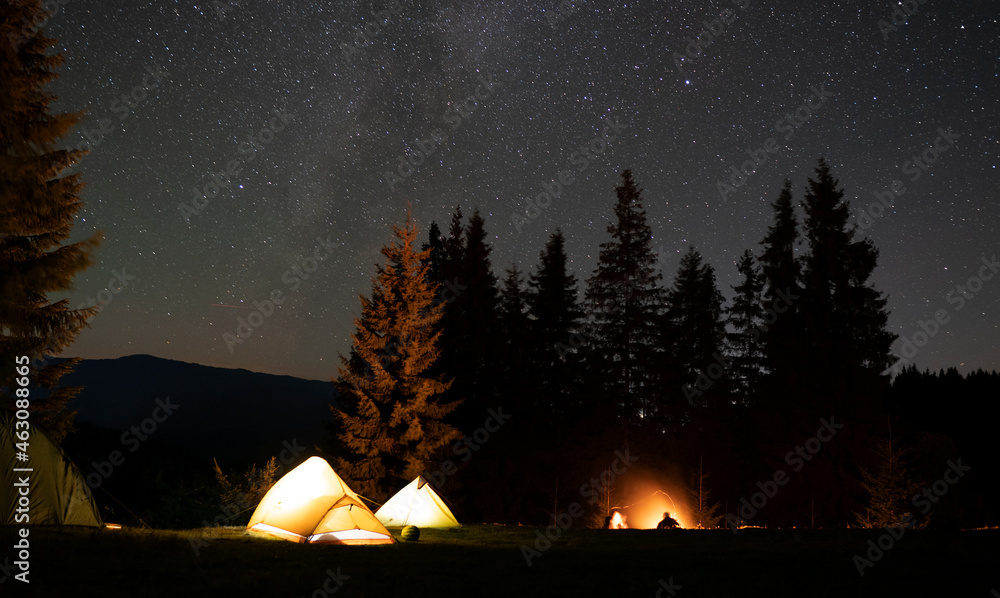 Astrophotography. Night camping. Bright burning bonfire and illuminated ...