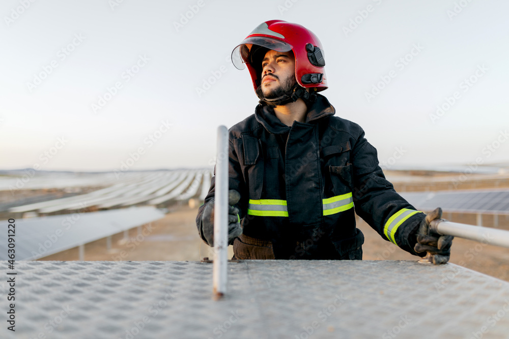 Fireman standing on fire truck ladder Stock Photo | Adobe Stock