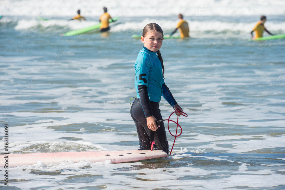 cute little girl taking a surf lesson Stock Photo | Adobe Stock