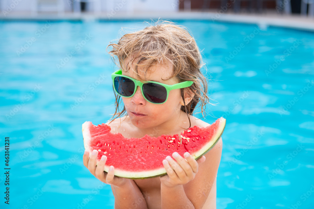 Child eating watermelon near swimming pool during summer holidays. Kids ...