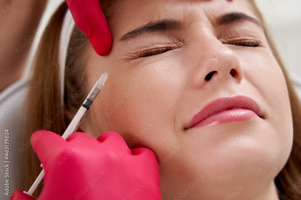 Beauty injections into young female face. Smoothing of mimic wrinkles ...