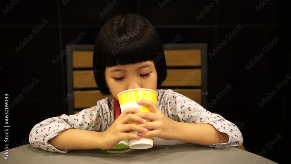 Little girl drink the coke at fast food center. Social distancing at ...