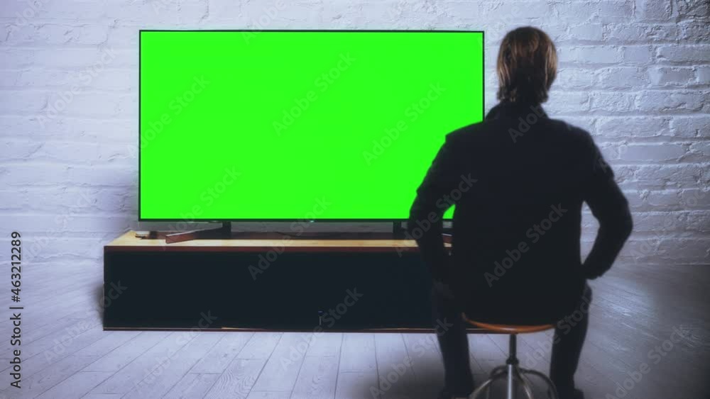 Watching Green Screen TV Sitting at Home Man Watch Television. Back of a man watching a big ...
