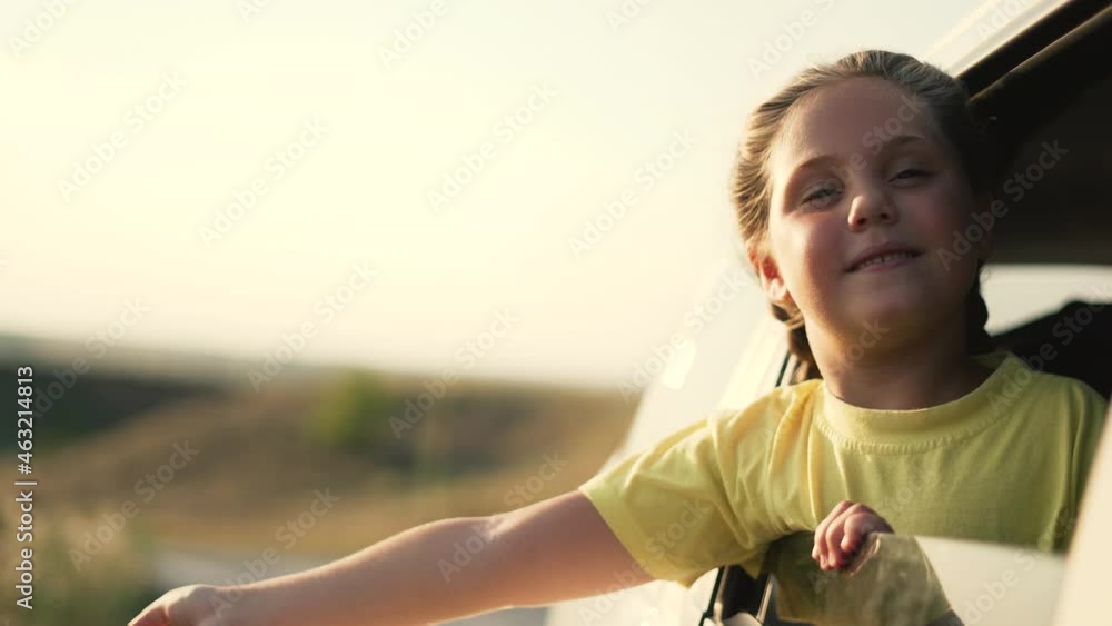 Child in car window. Family car trip. Child hair in wind. Girl looks ...