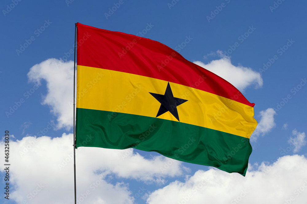 Ghana flag isolated on the blue sky background. close up waving flag of Ghana. flag symbols of ...