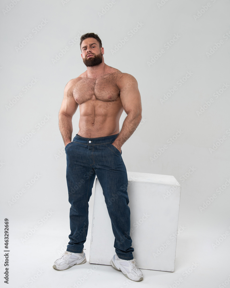 Shirtless bodybuilder in blue jeans at white background in studio Stock ...