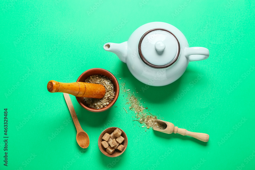 Teapot, sugar cubes and dry tea on green background Stock Photo | Adobe ...