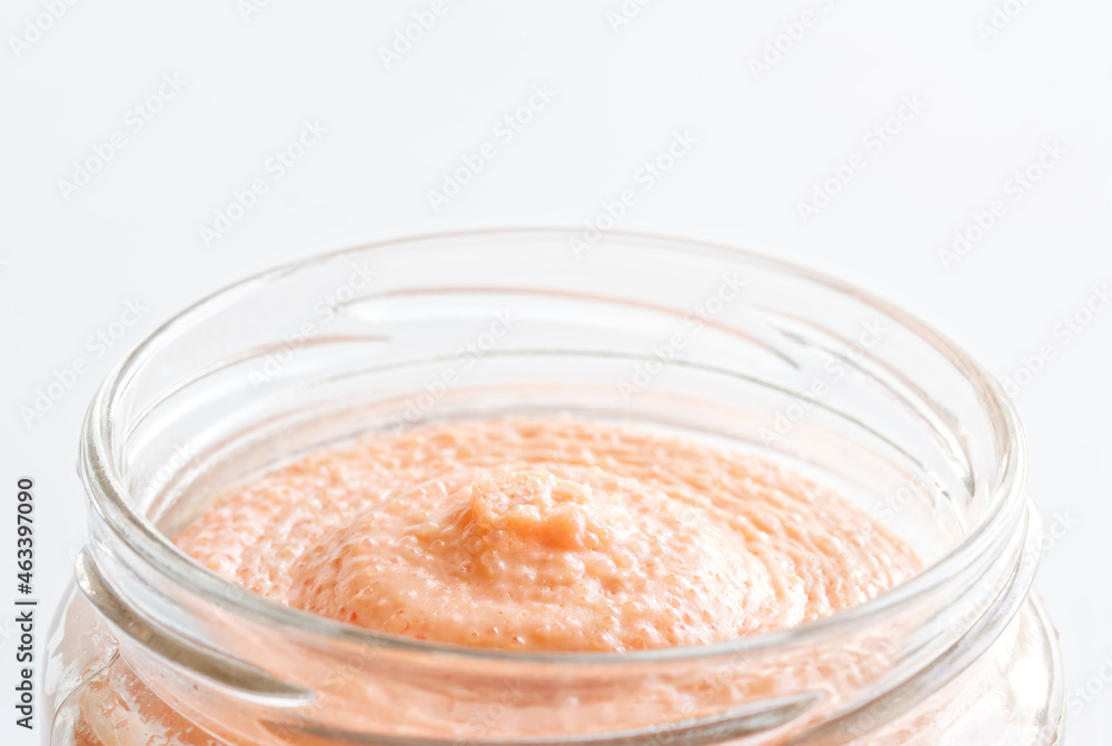 Pollock fish roe mixed with mayonnaise in an open glass jar. Macro ...