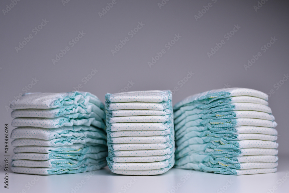 Tre stacks of baby disposable nappies over grey background. A large ...