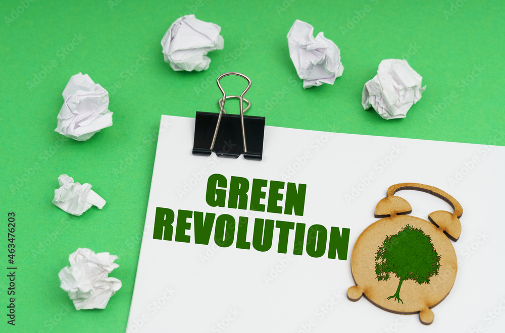 On a green background, crumpled paper and a white sheet with the ...