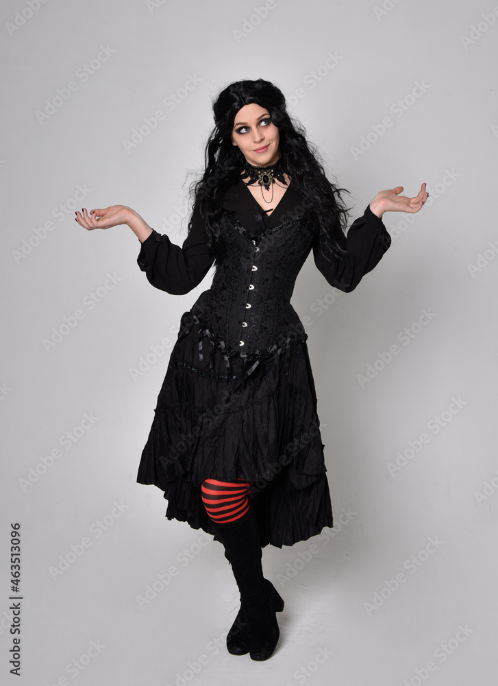 Full length portrait of dark haired woman wearing black victorian witch ...