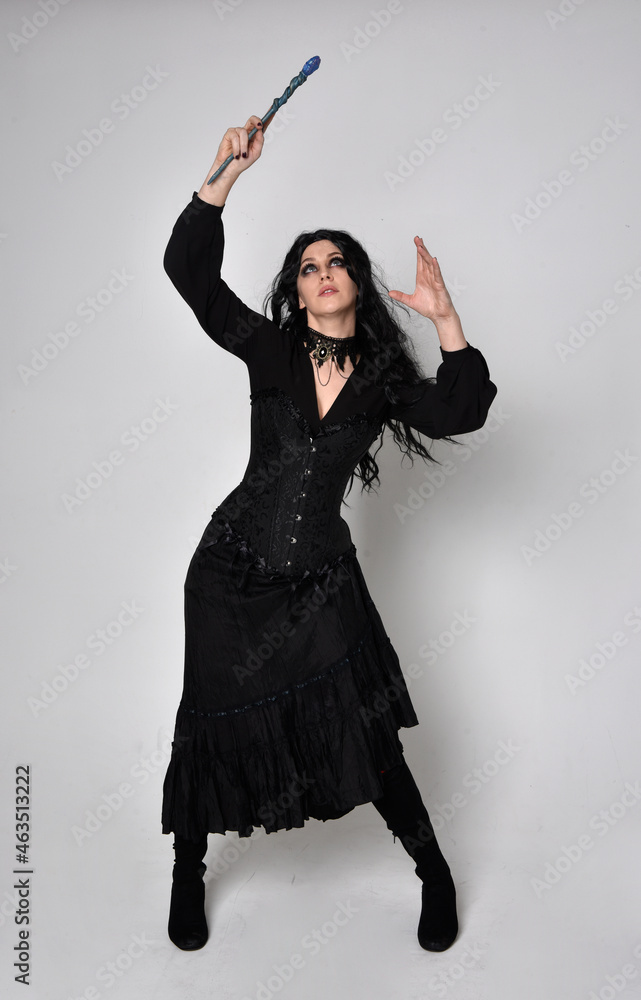 Full length portrait of dark haired woman wearing black victorian witch ...