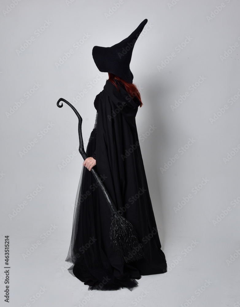 Full length portrait of dark haired woman wearing black victorian witch ...